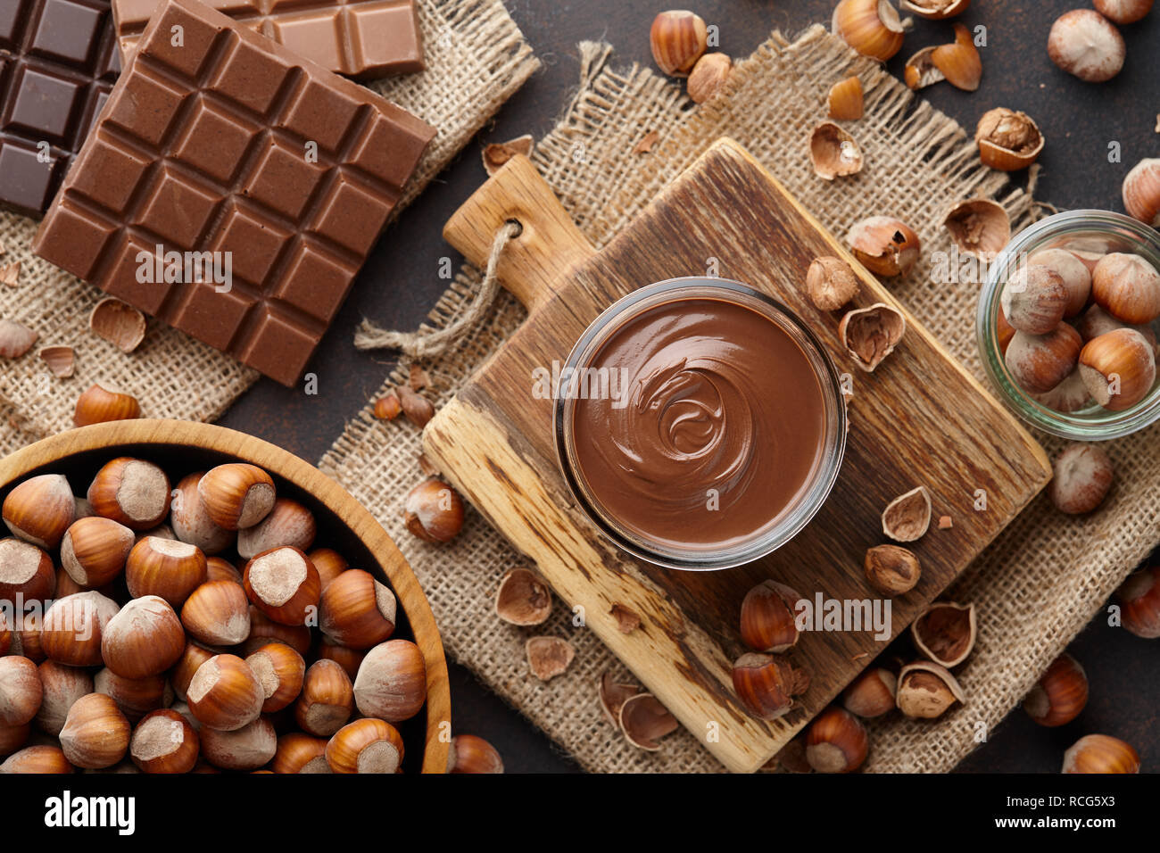 Chocolate spread or nougat cream with hazelnuts in glass jar, bowl of ...