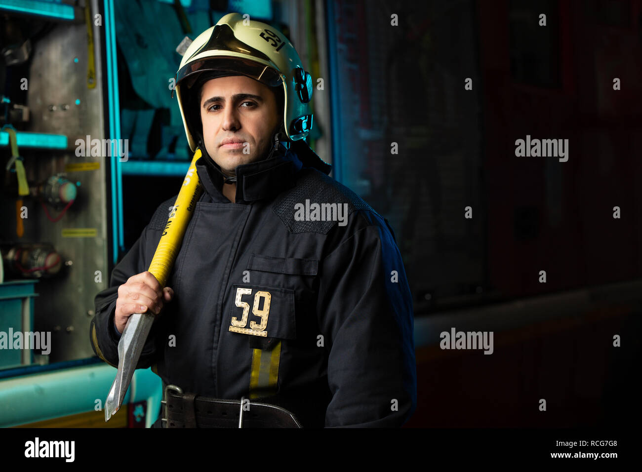 Image of man firefighter with pick near fire truck Stock Photo - Alamy