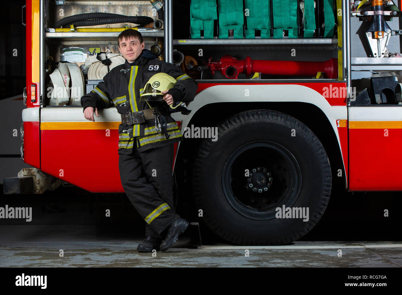 Image of young fireman man near fire truck Stock Photo - Alamy