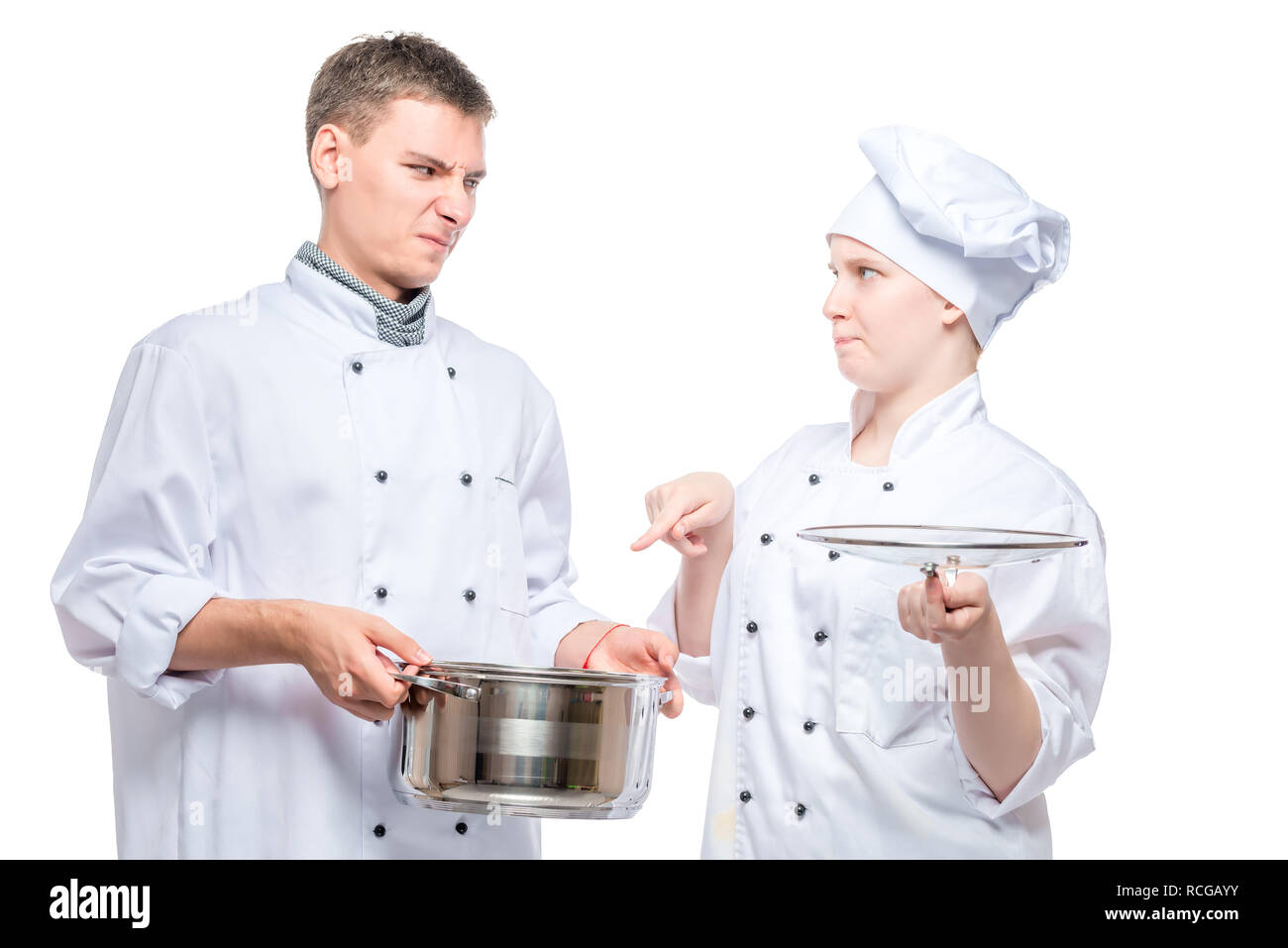 chef looks at a cooked dish of a young cook with a reproach on a white ...