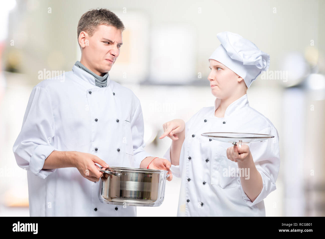 chef looks at a cooked dish of a young cook with reproach in the ...