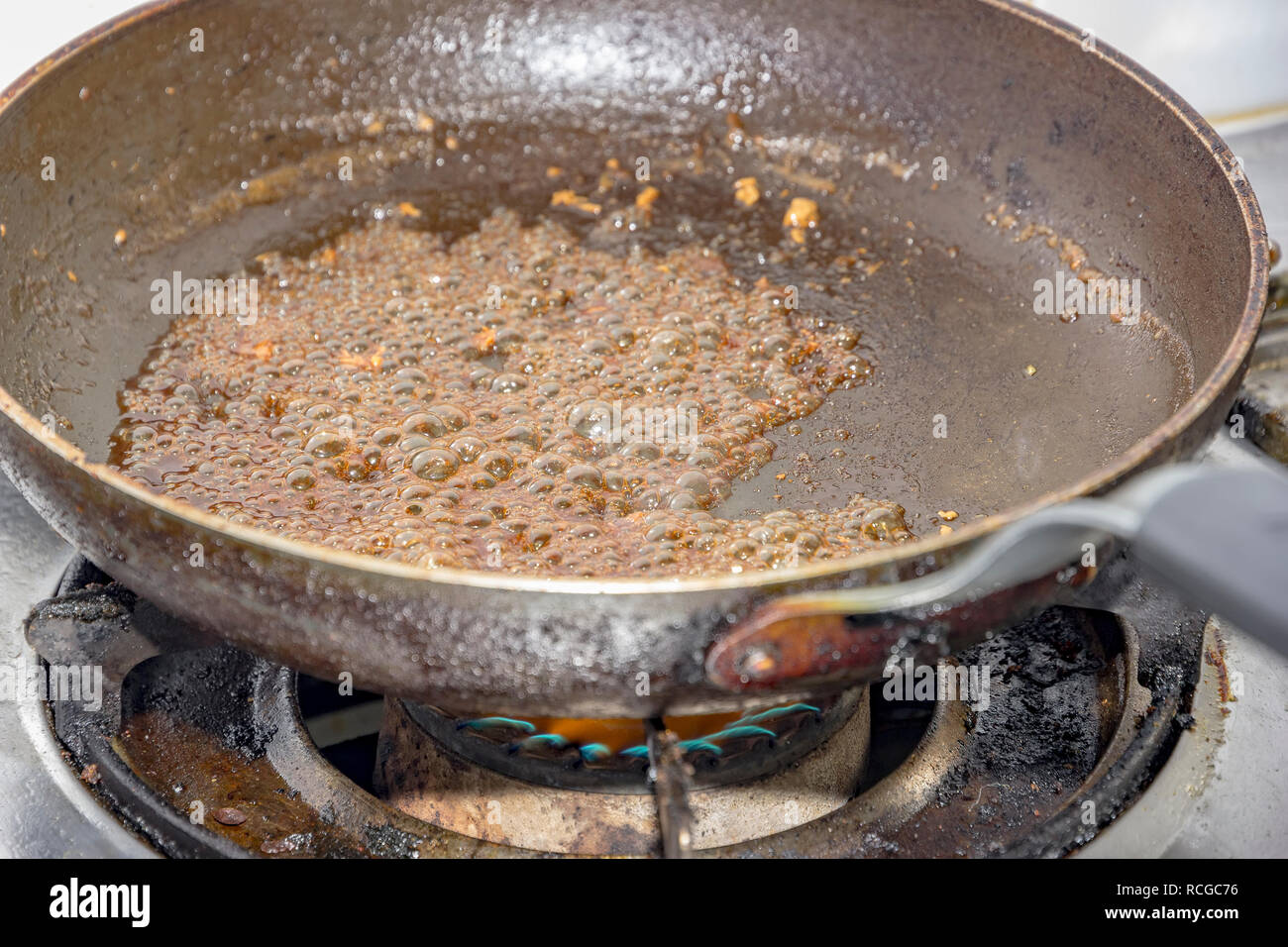 sugar caramelizing in a frying pan at gas stove in kitchen Stock Photo ...