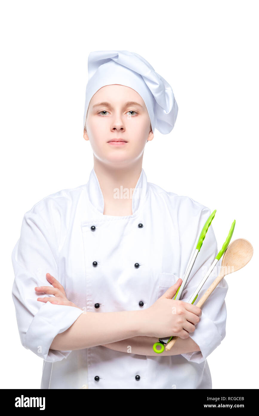 vertical portrait of a young cook with a spoon and culinary tongs ...