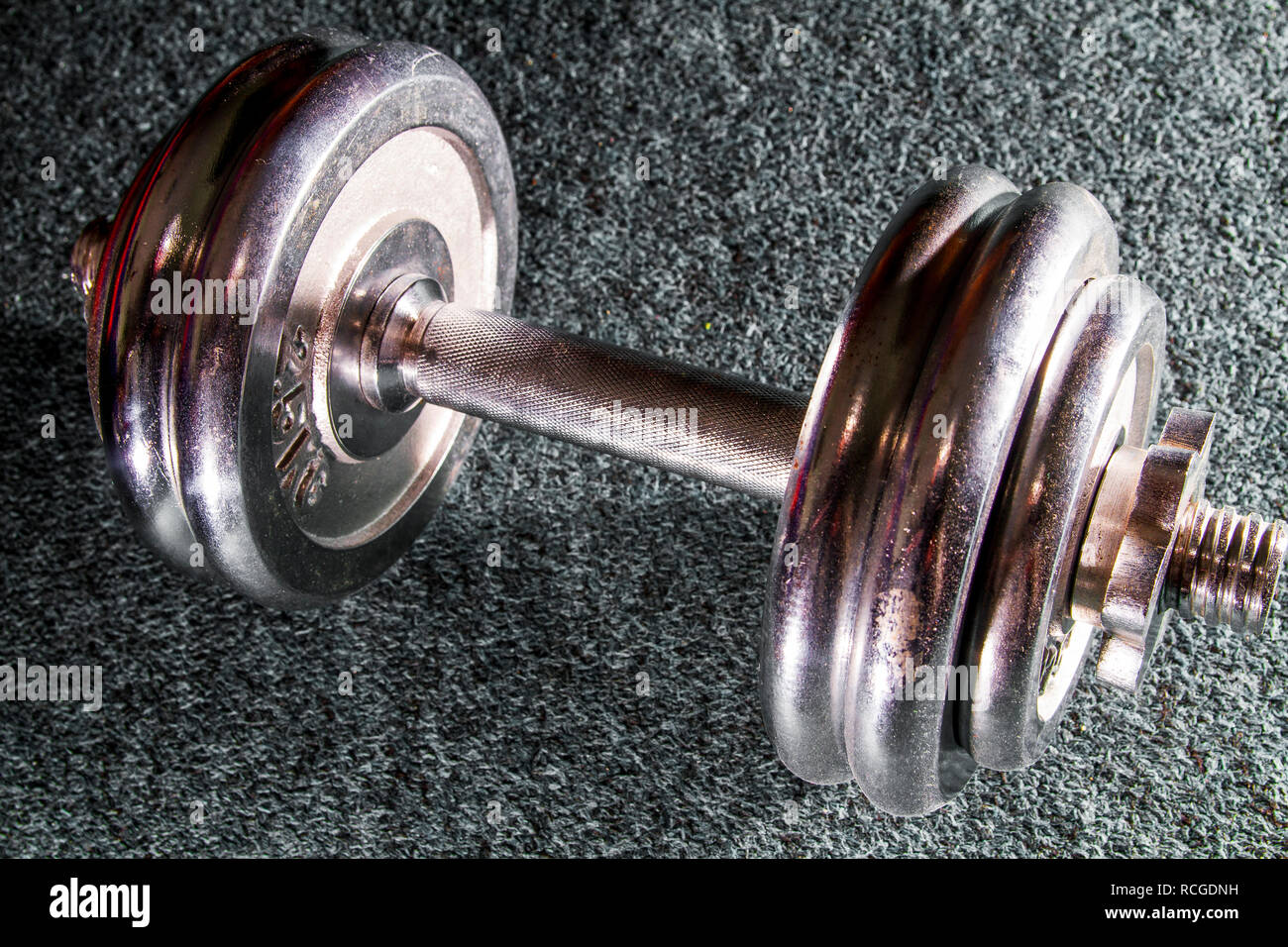 Heavy metal weight on a gym floor Stock Photo - Alamy
