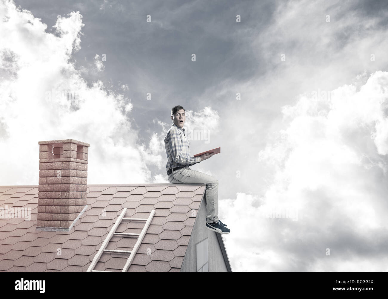 Handsome man on brick roof against cloud scape reading book Stock Photo ...