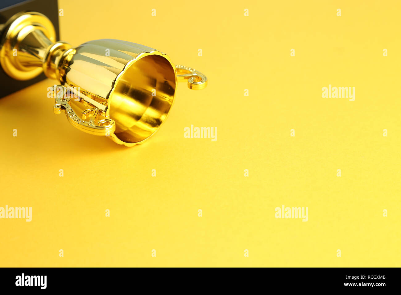 Champion golden trophy on yellow background Stock Photo - Alamy