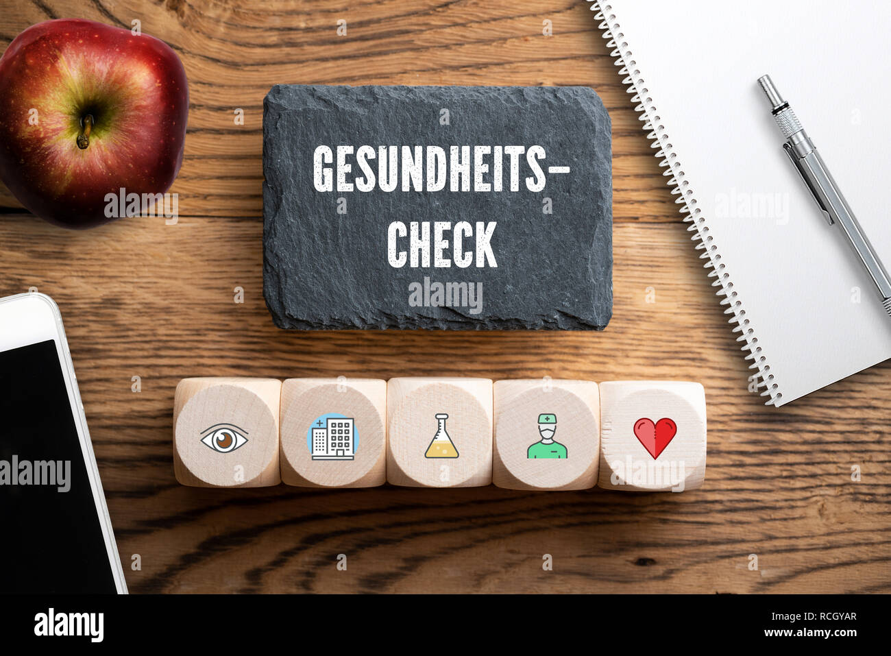 message "health checkup" in German on a slate plate with medical icons ...