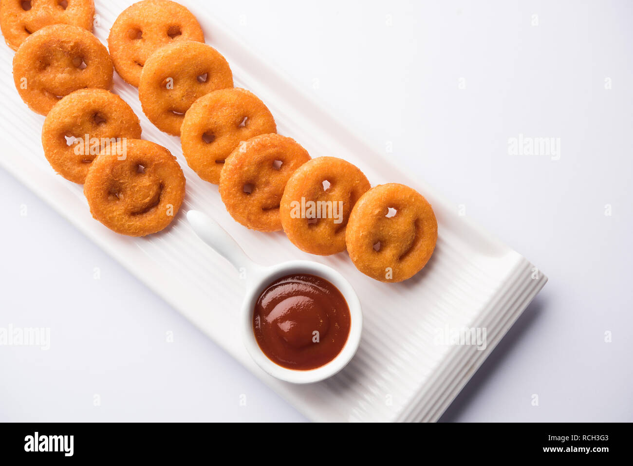 Crunchy potato smiling face chips or fried smile faced snacks served ...