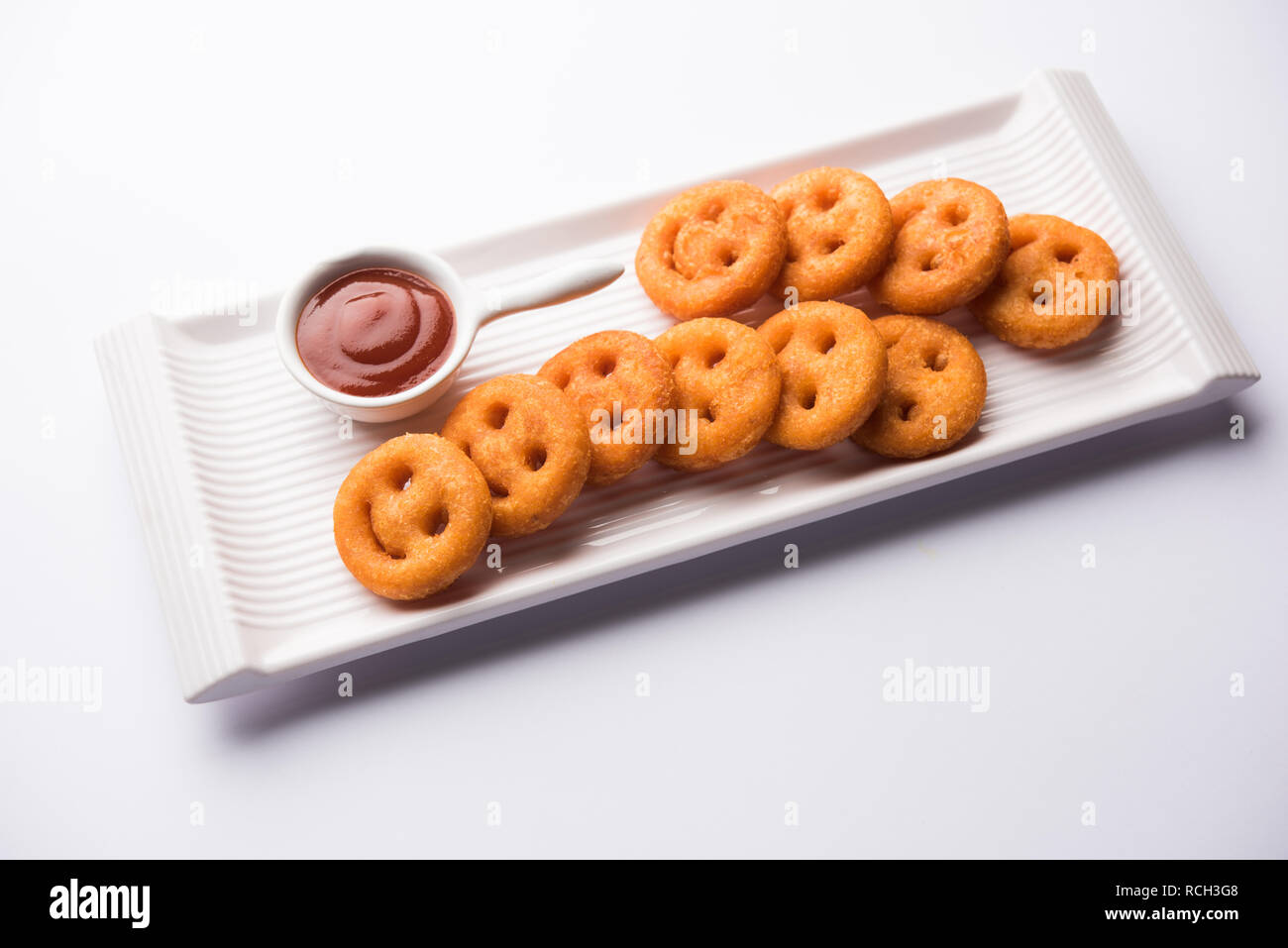 Crunchy potato smiling face chips or fried smile faced snacks served ...