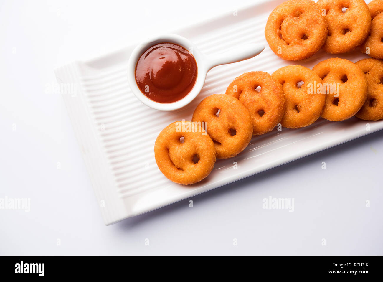 Crunchy potato smiling face chips or fried smile faced snacks served ...