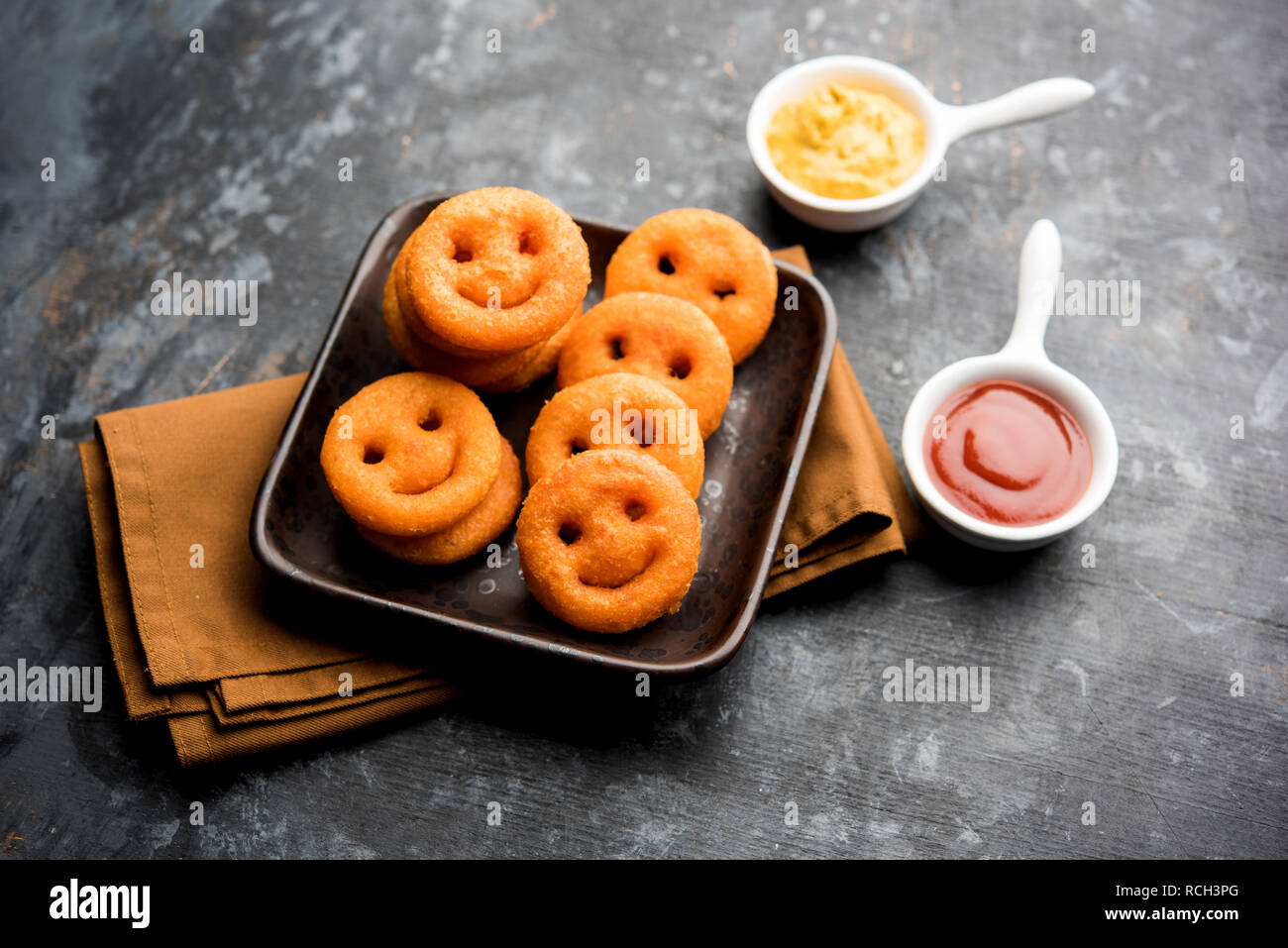 Crunchy potato smiling face chips or fried smile faced snacks served ...
