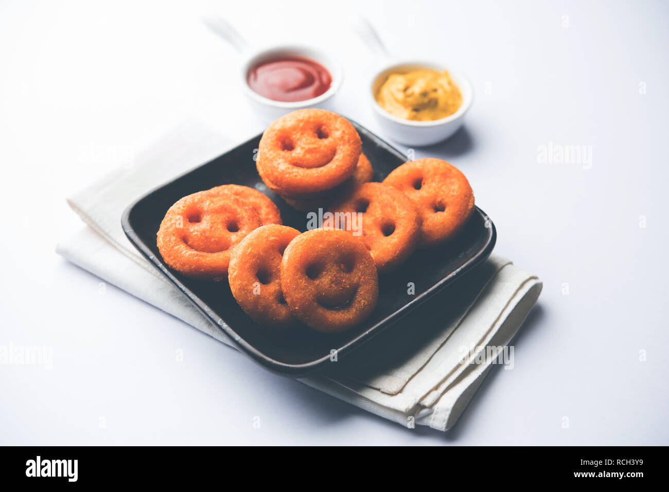 Crunchy potato smiling face chips or fried smile faced snacks served ...