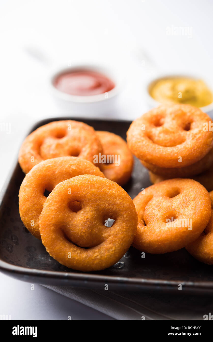 Crunchy potato smiling face chips or fried smile faced snacks served ...