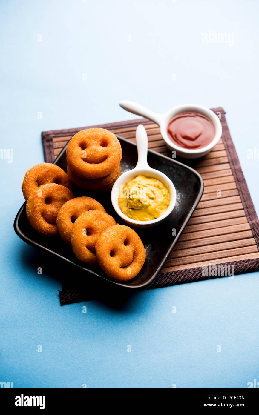 Crunchy potato smiling face chips or fried smile faced snacks served ...