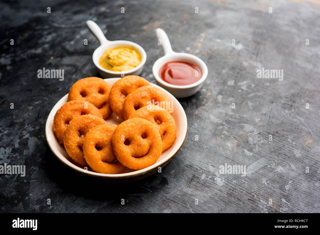 Crunchy potato smiling face chips or fried smile faced snacks served ...