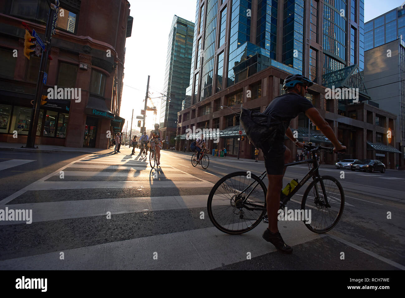 Early morning commuters on the streets of Toronto in summer sunshine ...