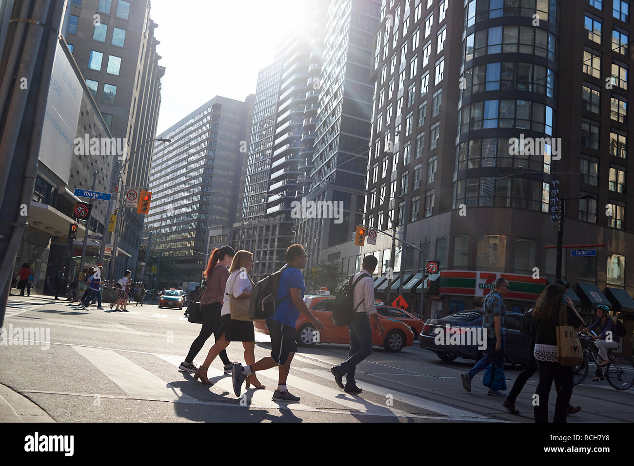 Early morning commuters on the streets of Toronto in summer sunshine ...