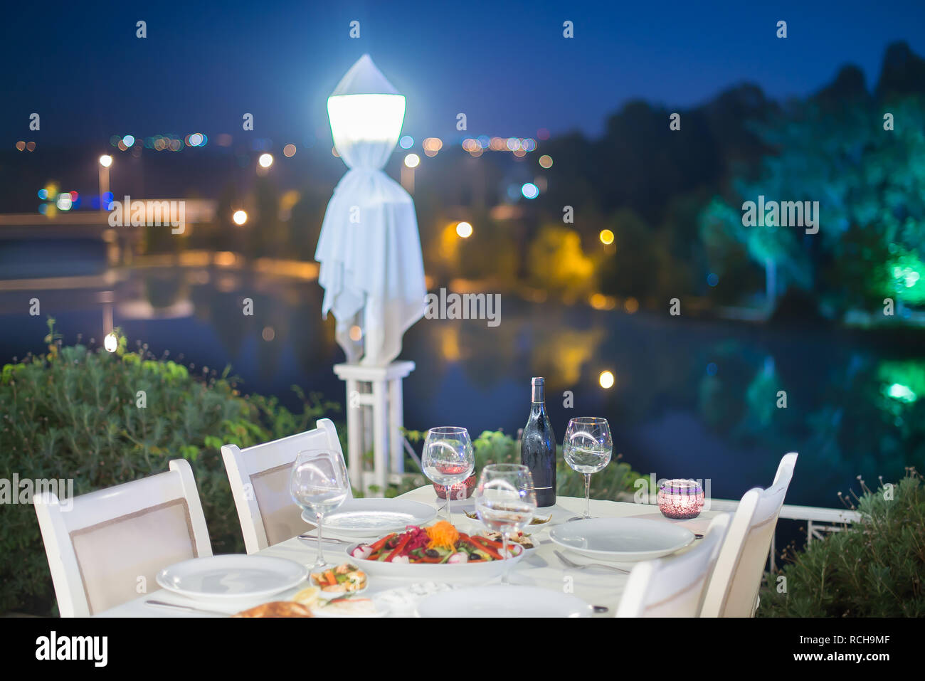 Open air restaurant table at night. Romantic dinner ambiance. Dinner ...
