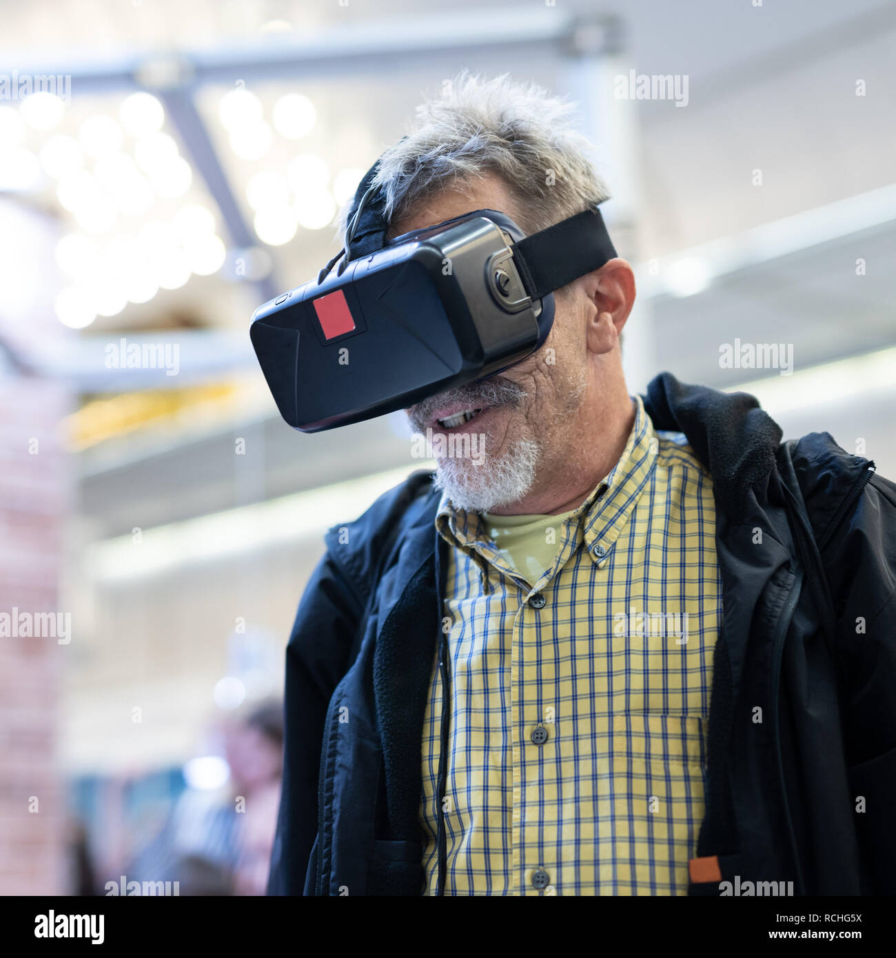 Senior man wearing virtual reality goggles watching virtual reality ...