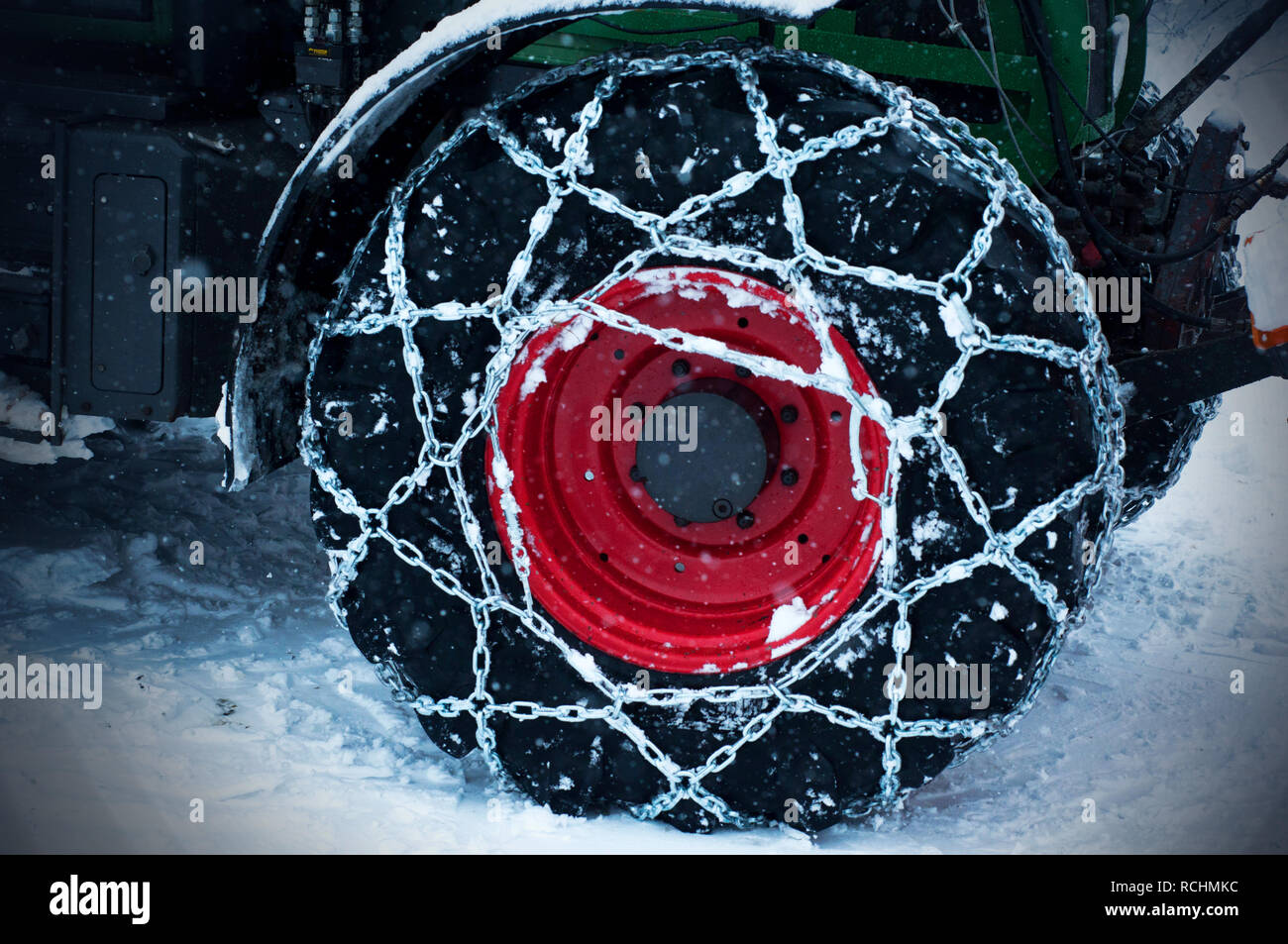 Winter scenery. Logging machine giant wheels equipped with snow chains ...