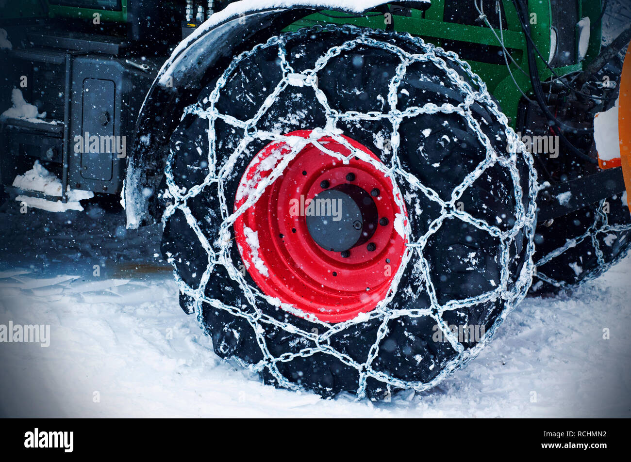 Winter scenery. Logging machine giant wheels equipped with snow chains ...