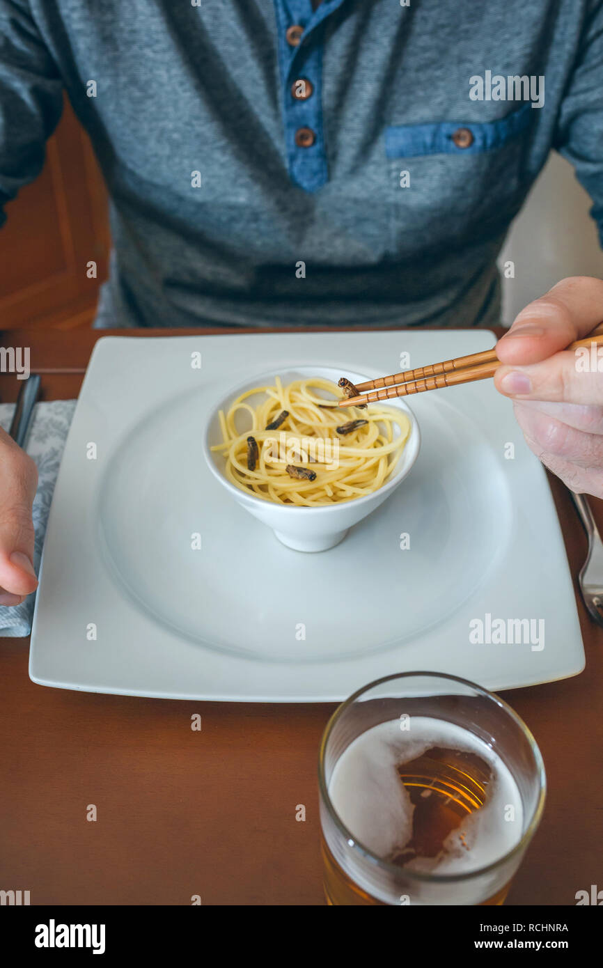 Man eating spaghetti and crickets Stock Photo - Alamy