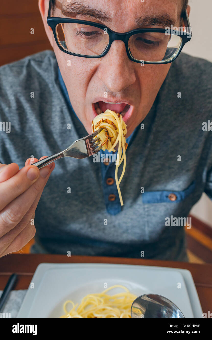 Man eating spaghetti with worms Stock Photo - Alamy