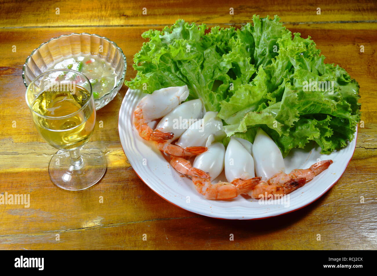 shrimp stuffed squid cocktail dipping with spicy sauce and glass of ...