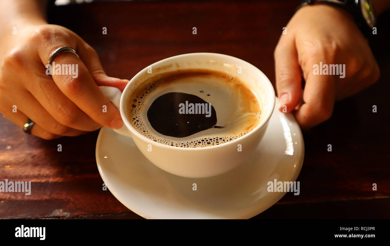 holding a cup of coffee with hands Stock Photo - Alamy