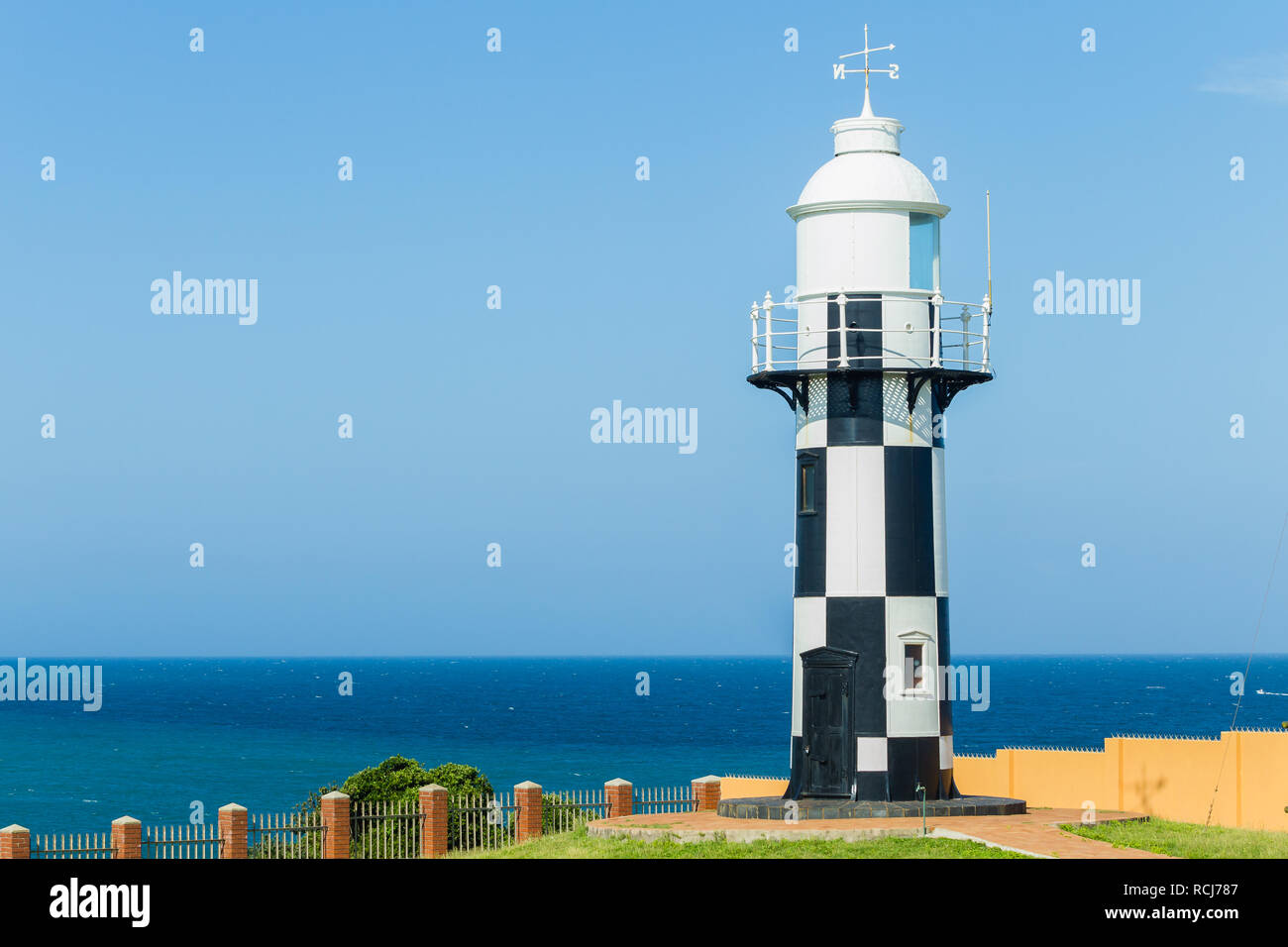 Lighthouse beacon black and white on headland point overlooking windy ...