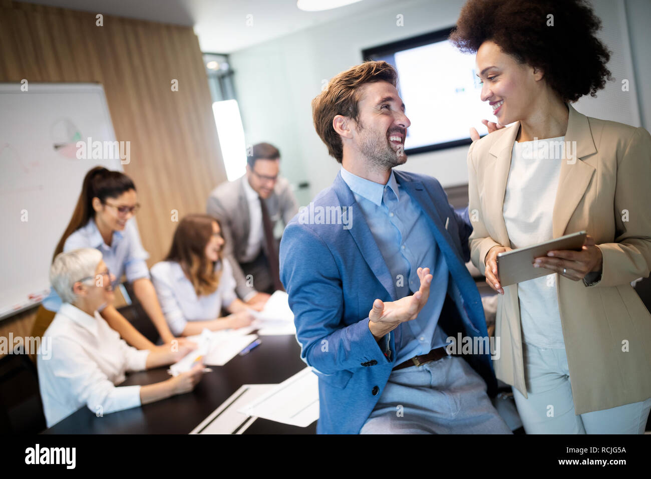 Happy business colleagues in modern office working together Stock Photo ...