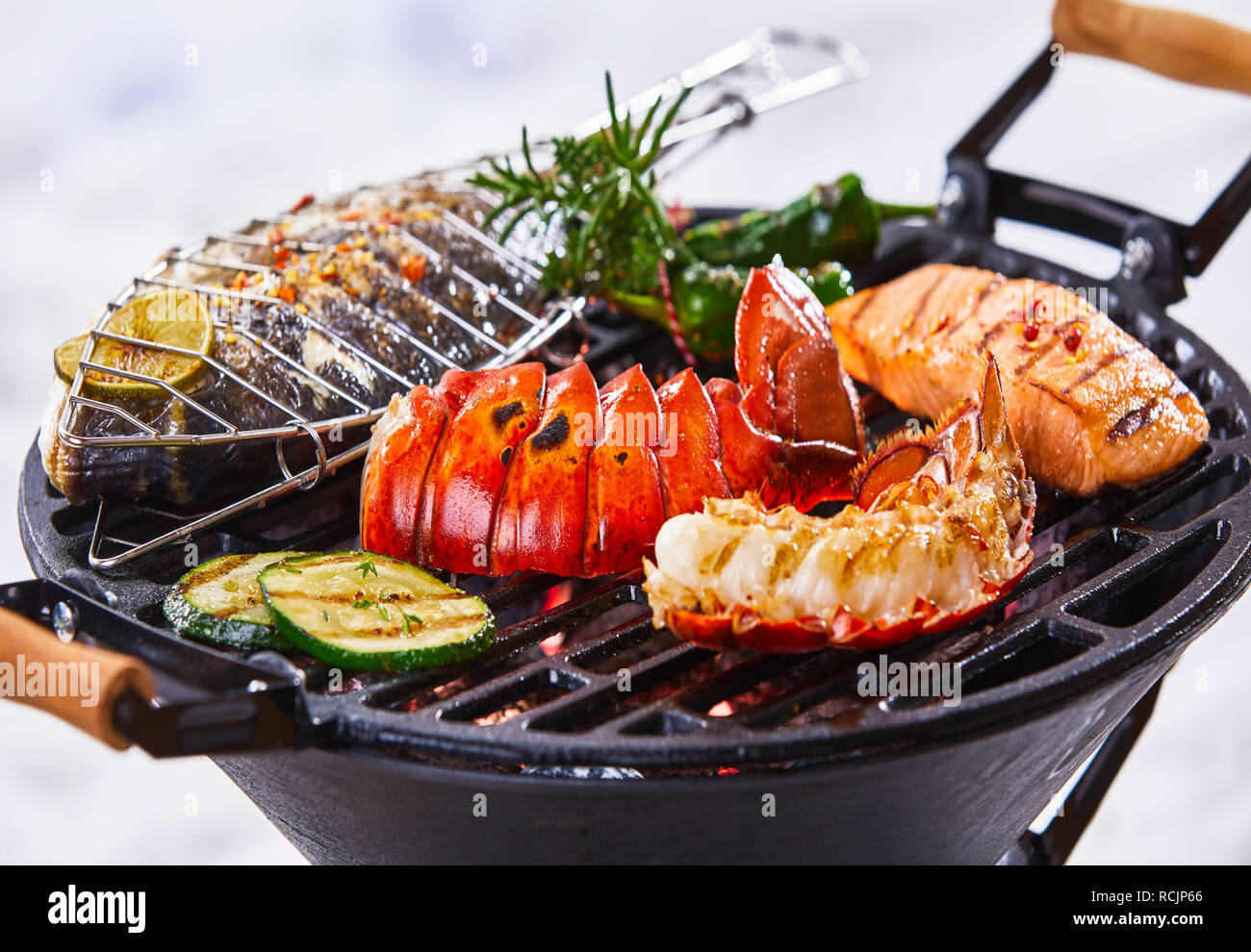 Gourmet seafood winter barbecue with crayfish tails, salmon and whole ...