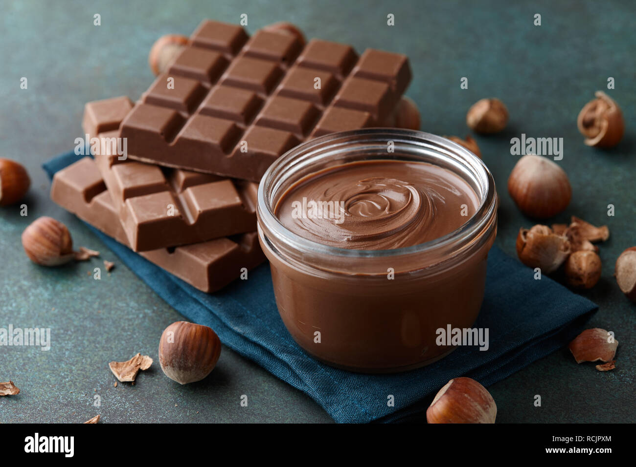 Chocolate spread with hazelnuts on blue green countertop Stock Photo ...