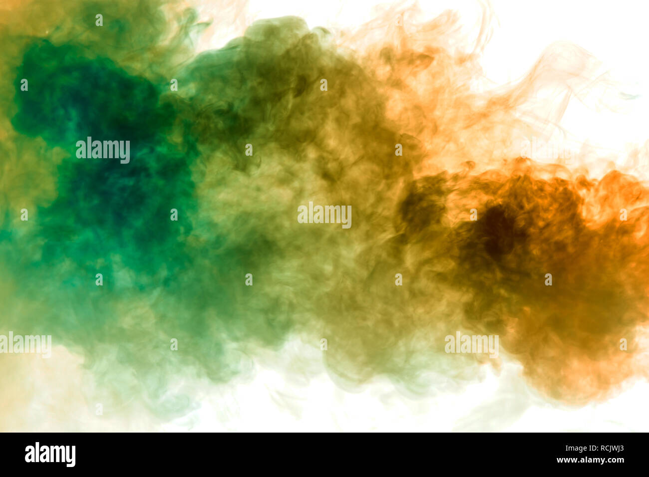 Blue, green and yellow smoke swirls on a white background depicting a ...