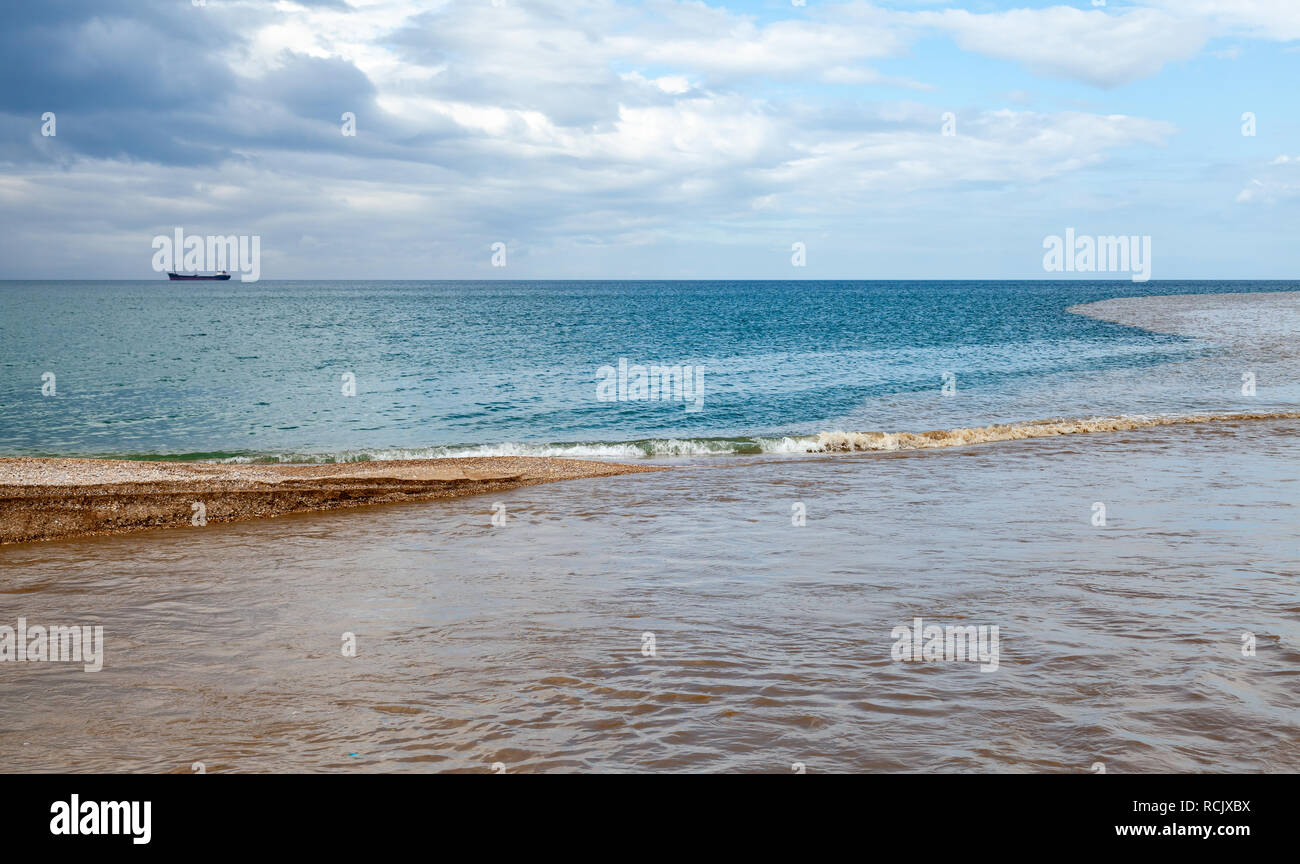 Summer seascape with muddy river water mixed with blue seawater empty ...