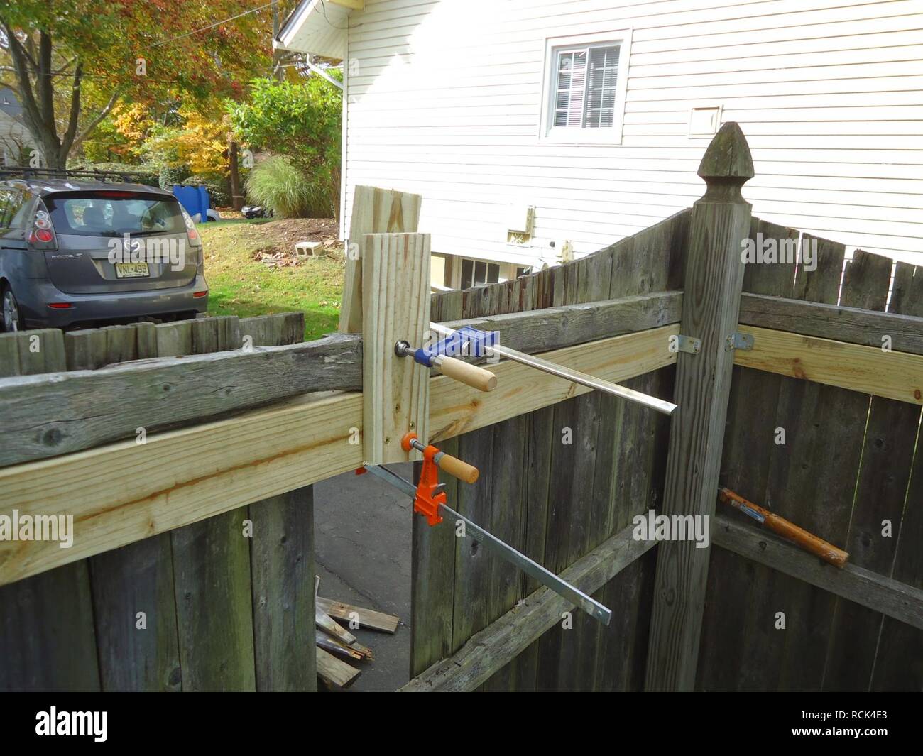 Aligning rotted support beam above with new board using clamps Stock ...