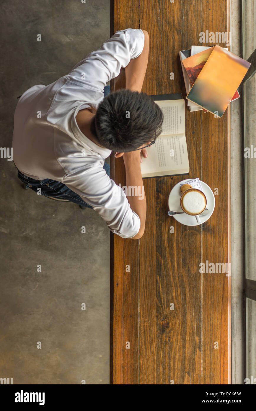 Reading book and drinking coffee at the cafe Stock Photo - Alamy