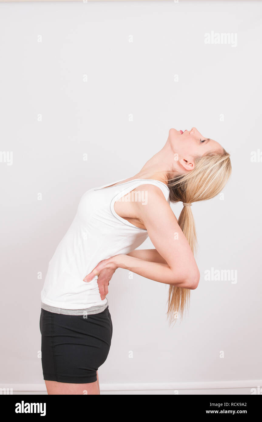 Side view of a blond woman stretching lower back Stock Photo - Alamy
