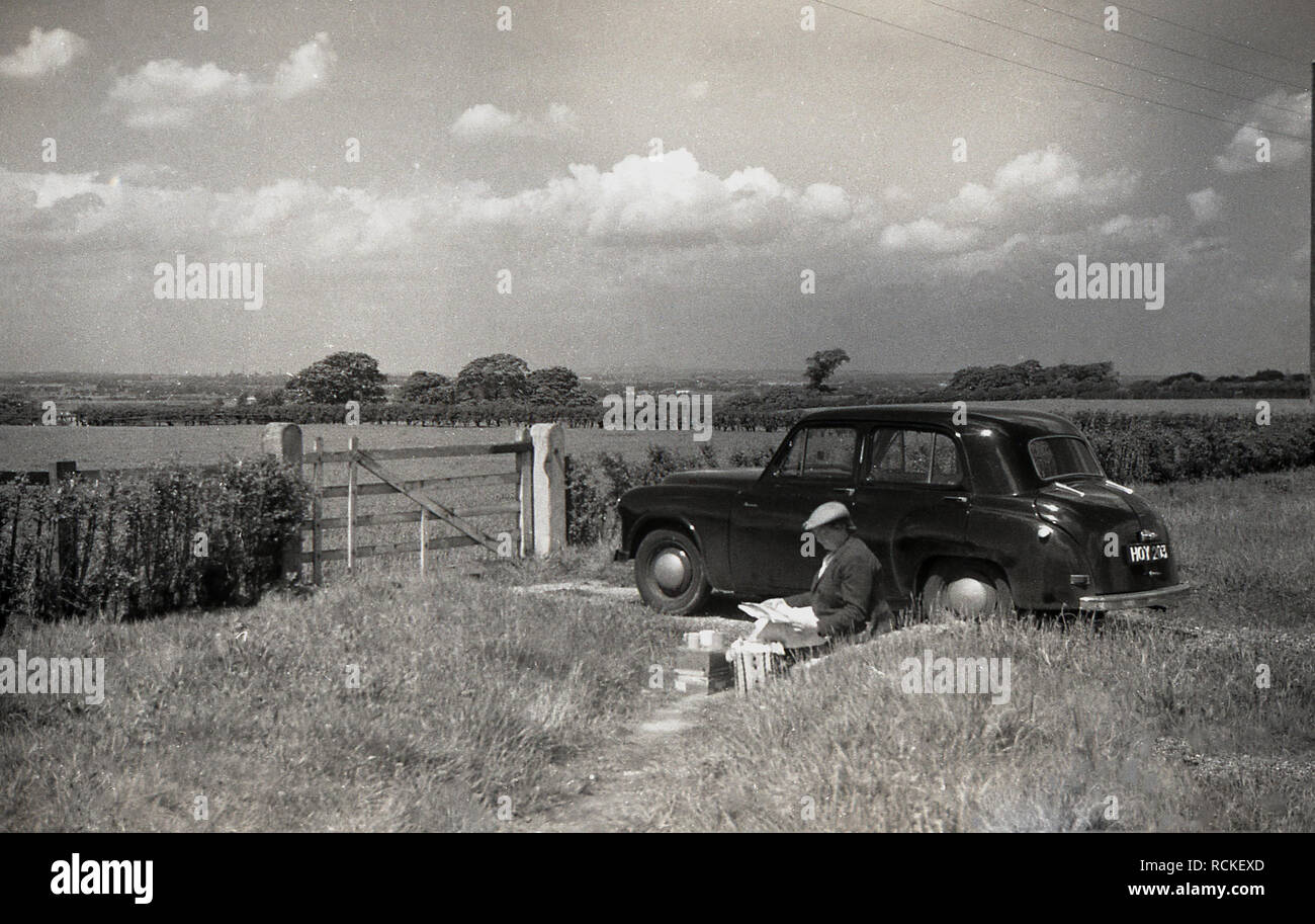 1950s, historical, outside on a grassy area beside a field in the ...