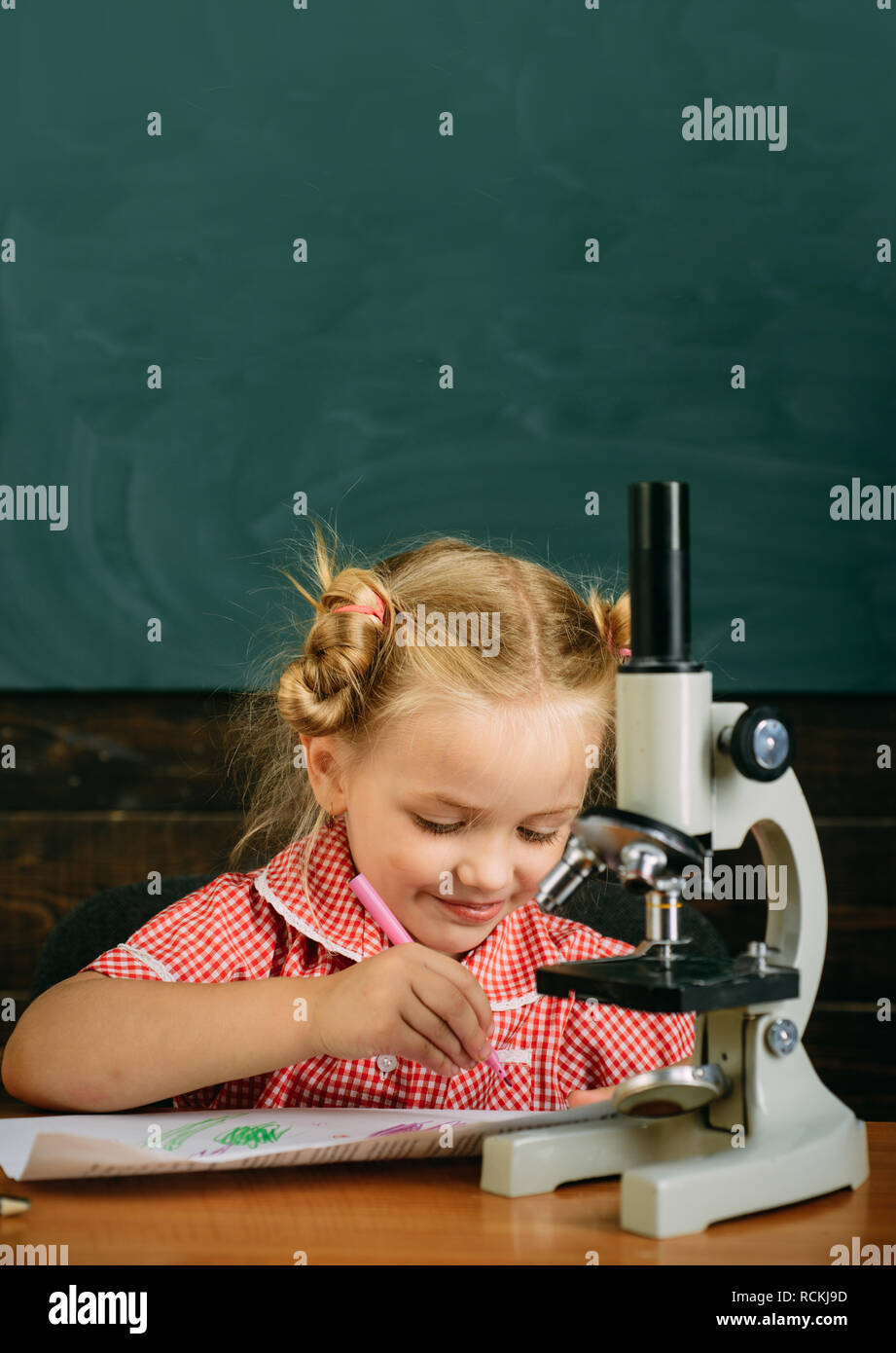 Cute child research with microscope optical instrument at school ...