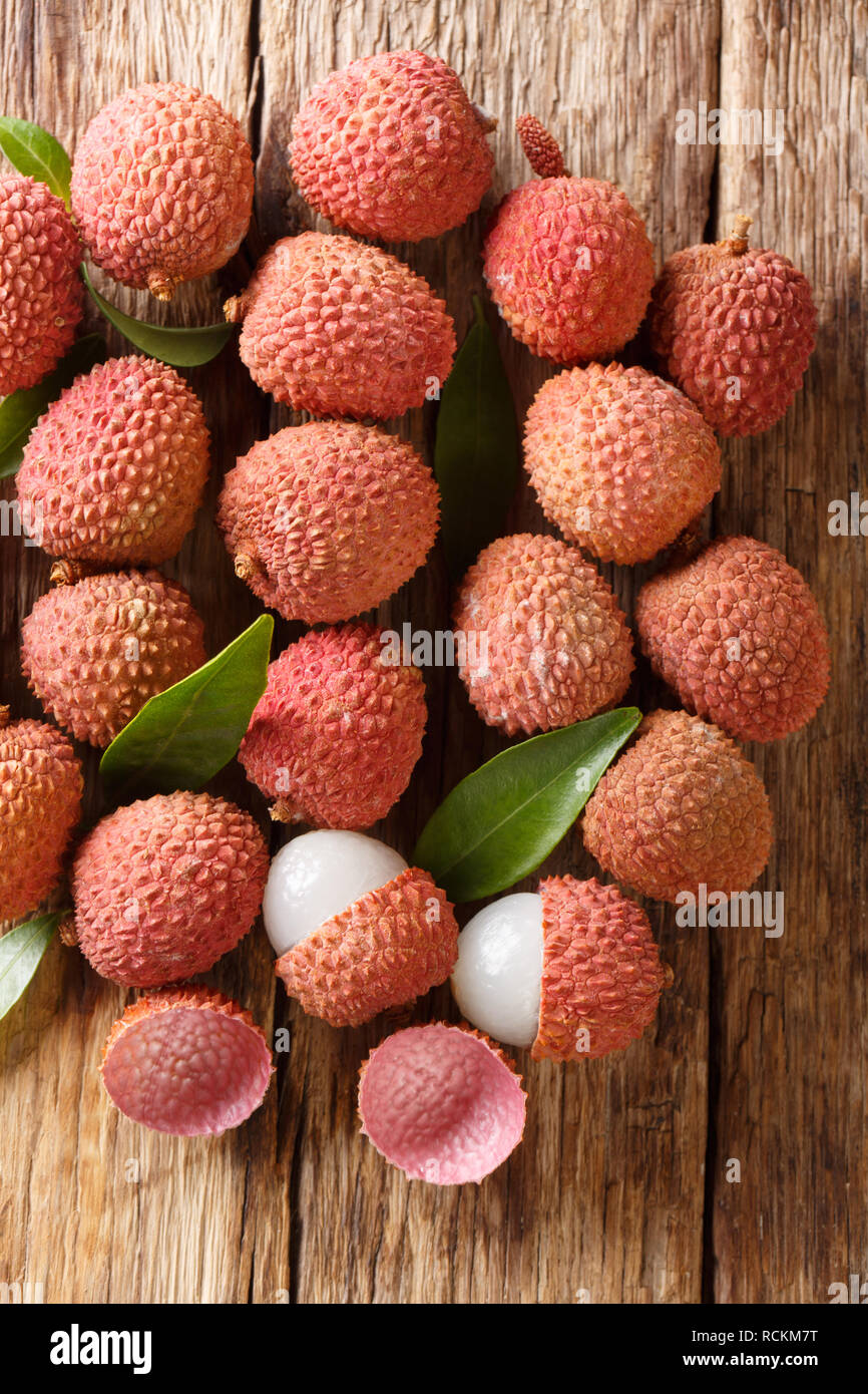 Fresh lychee and peeled showing the red skin and white flesh with green ...