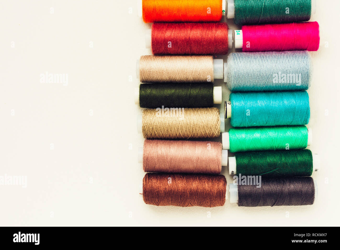 Colored sewing thread coils on white background with copy space for ...