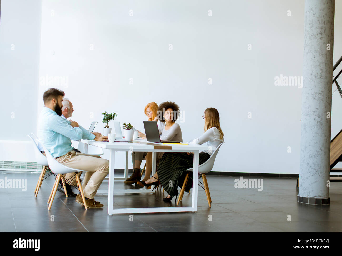 View of multiracial business people around table during staff meeting ...