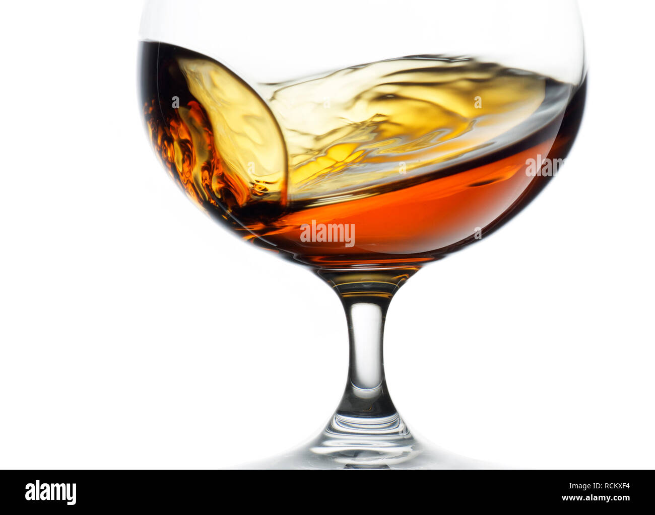 Glass of cognac brandy, back lit, plain background, cropped Stock Photo ...