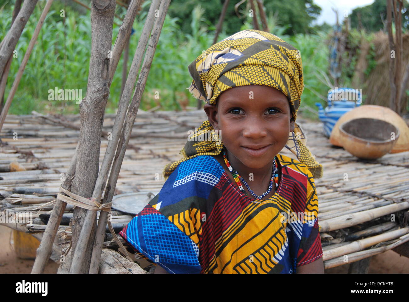 A little Fulani girl in front of her family's outdoor bed at the edge ...