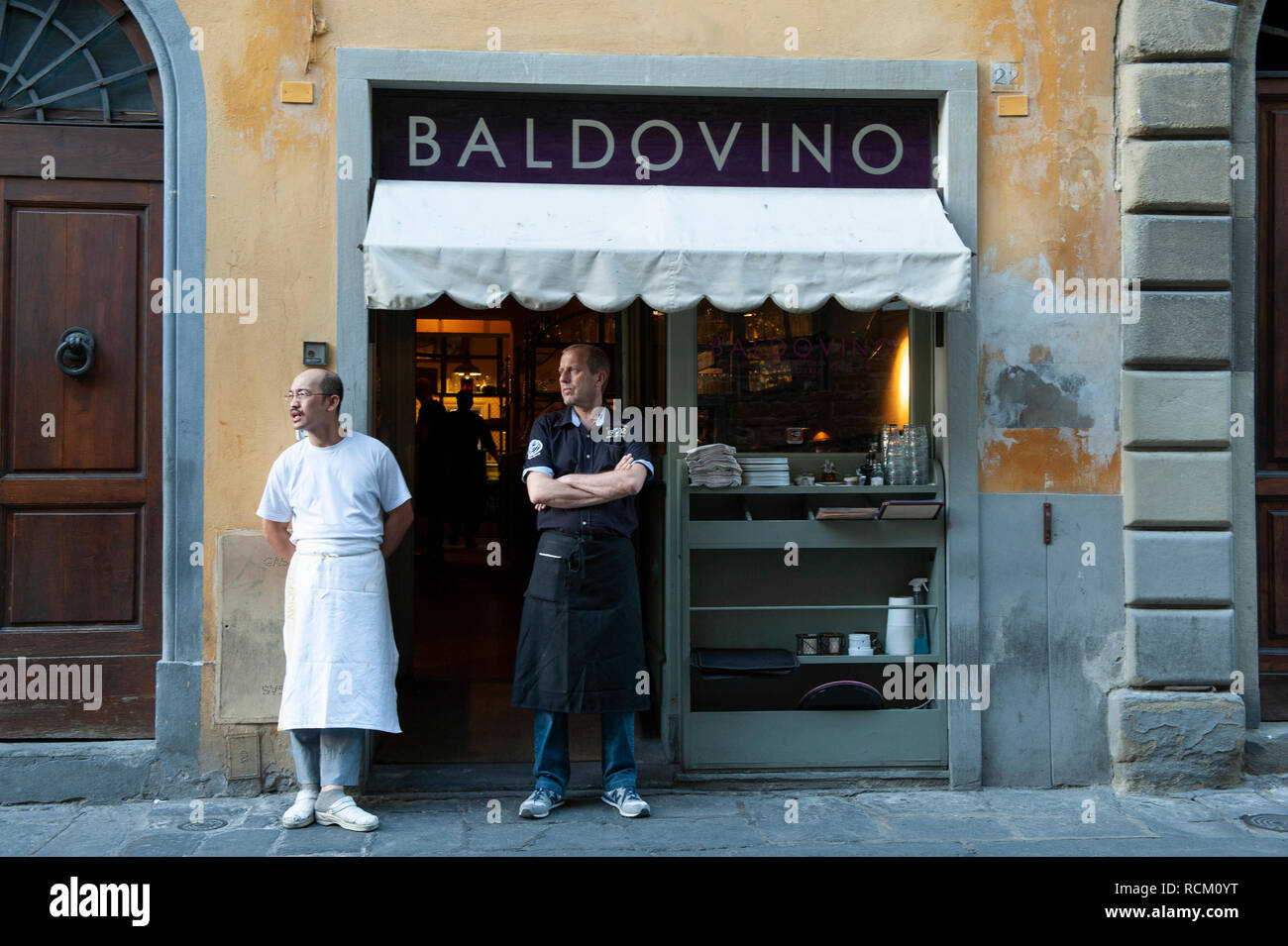 A waiter and chef standing outside Baldovino restaurant, Florence ...