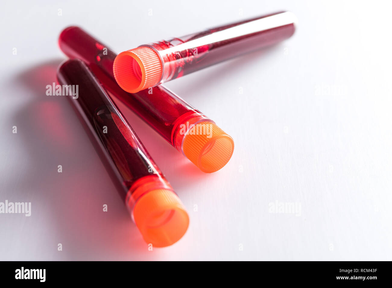 Test tubes with blood on white table with test chart and ballpoint pen ...