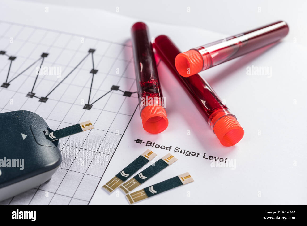 Test tubes with blood on white table with test chart and ballpoint pen ...