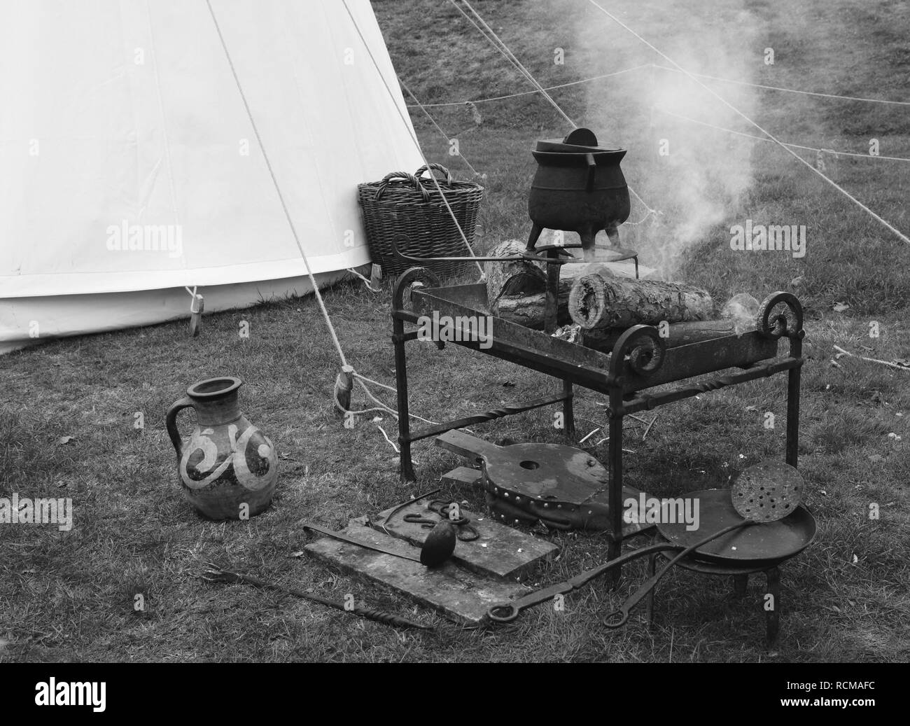 Campfire stove at a Medieval fair with a cast iron pot, bellows and ...