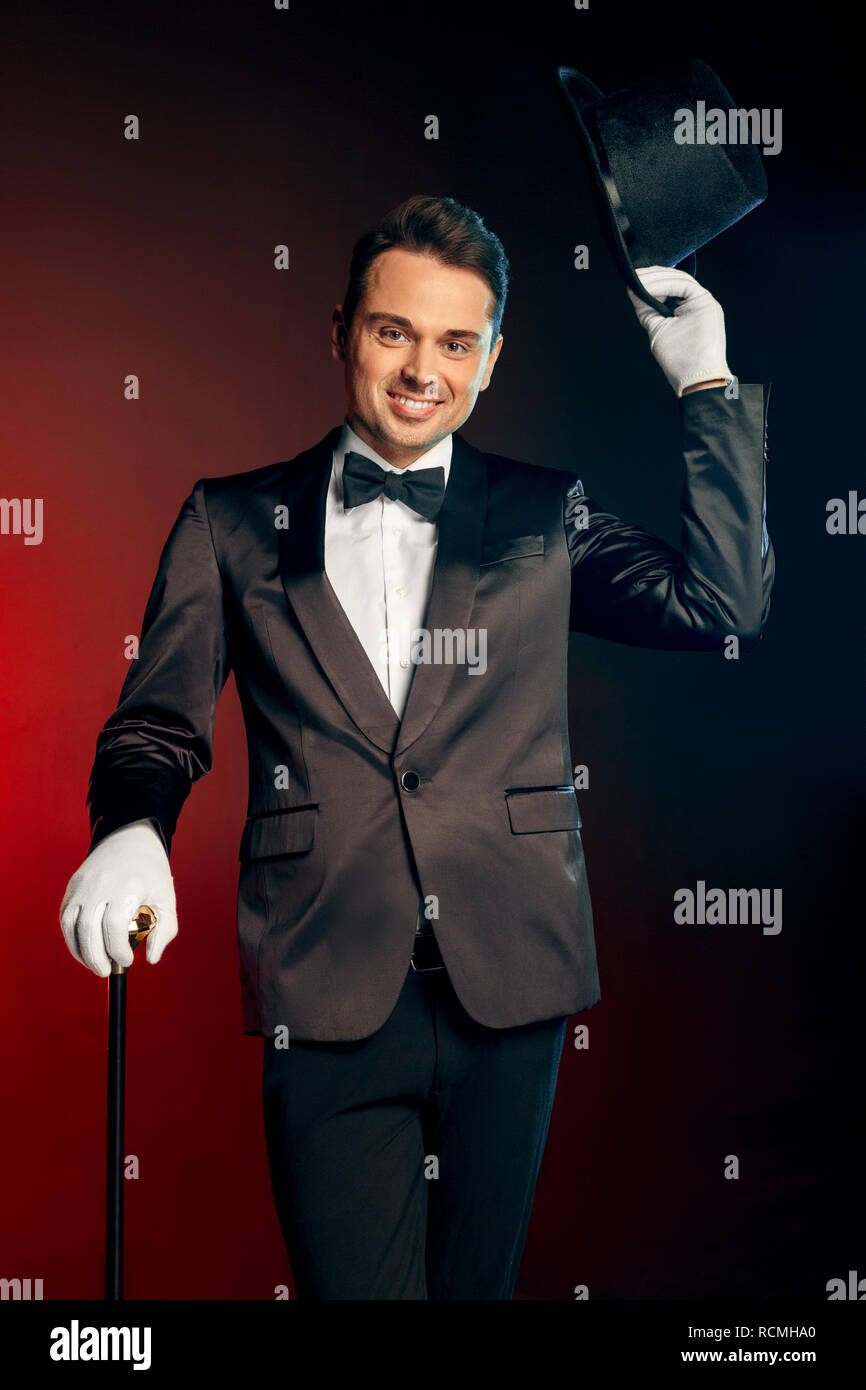 Professional showman wearing suit standing isolated on black and red ...